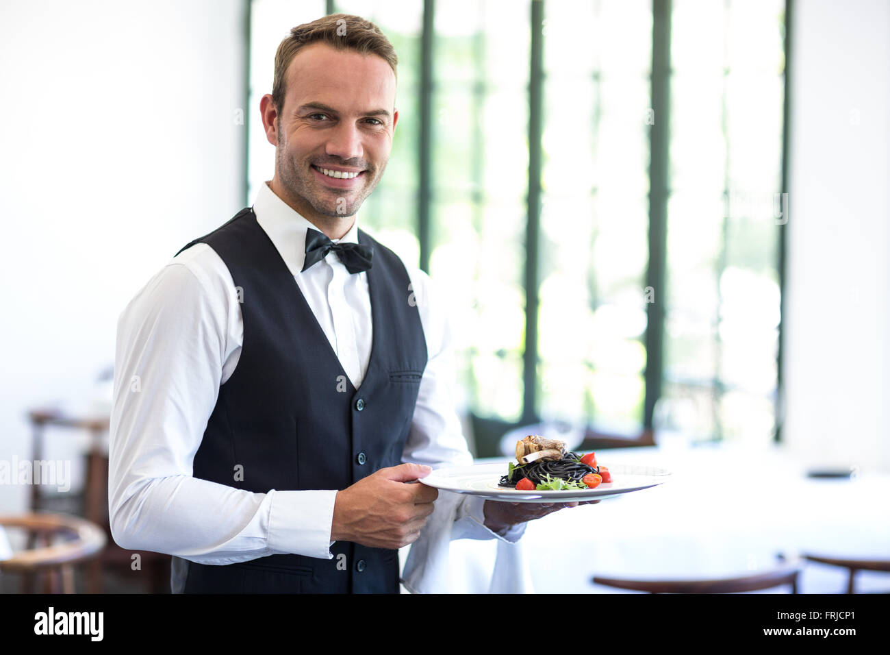 Waiter showing a dish Stock Photo - Alamy