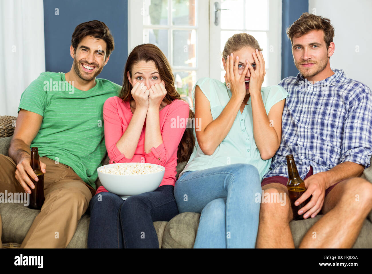 Portrait of scared women with male friends at home Stock Photo - Alamy