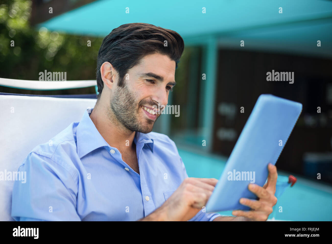 Smart man using digital tablet near pool Stock Photo - Alamy