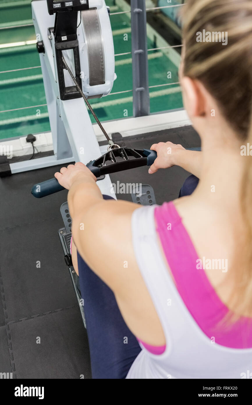 Woman exercising on rowing machine Stock Photo - Alamy