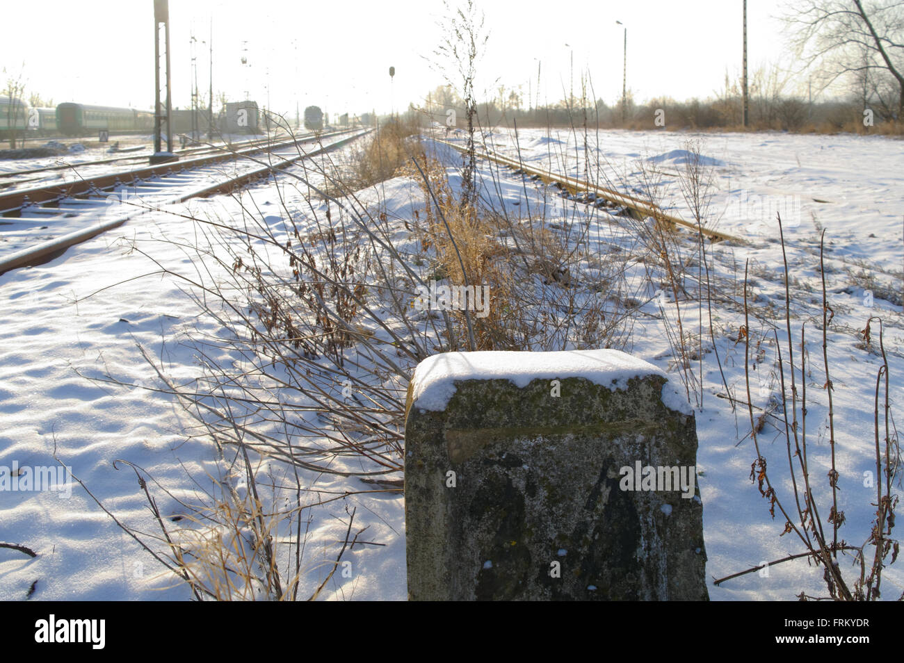 closeup of a low concrete post beside railway at the sunny winter ...
