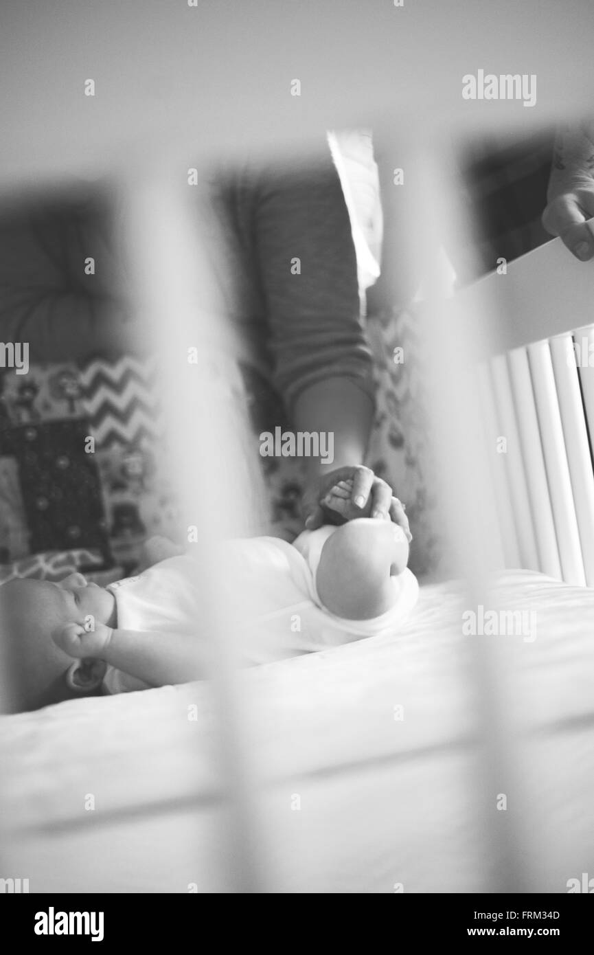 New mother and father with baby boy. Shot through crib bars Stock Photo ...