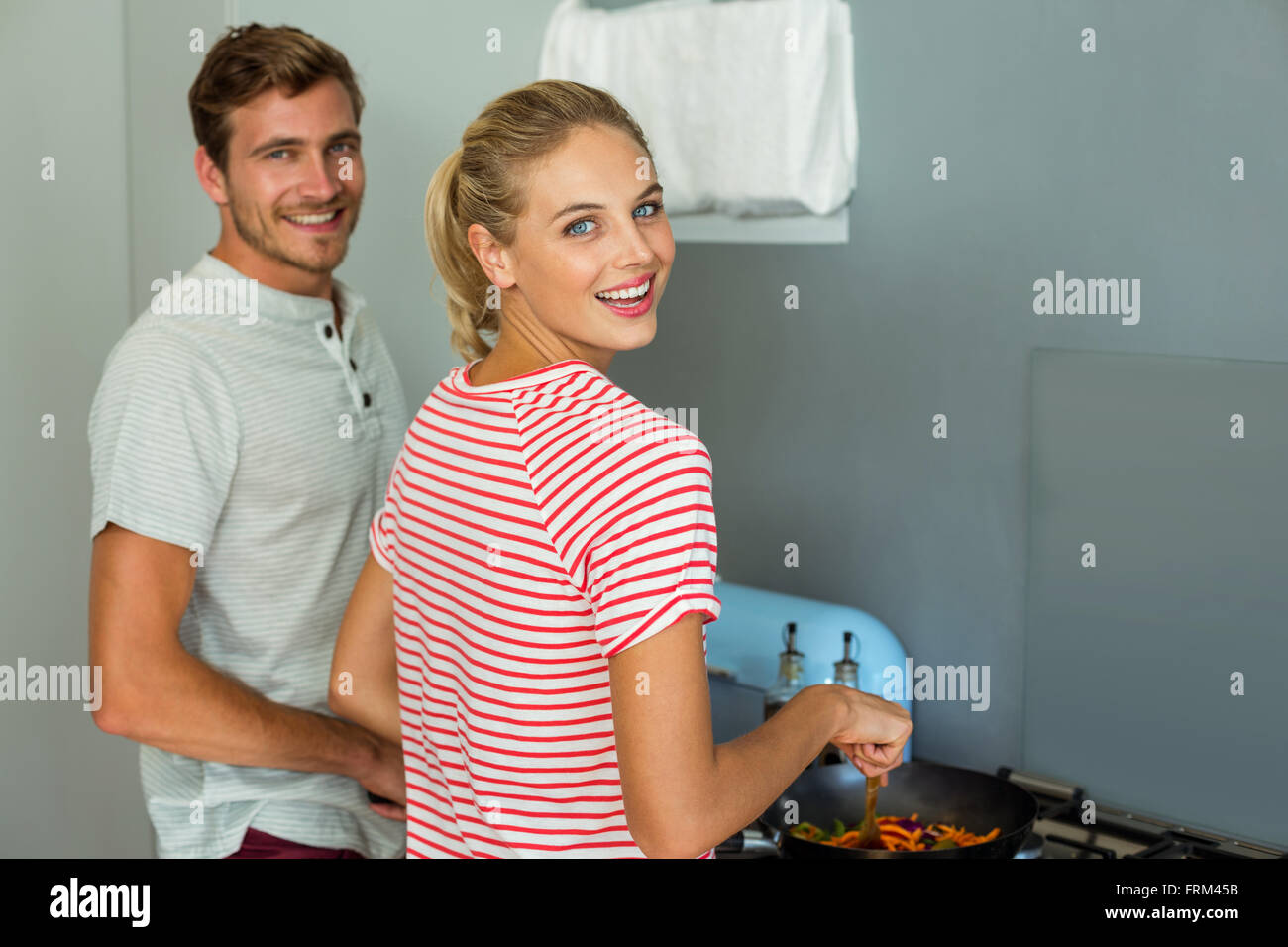 Portrait of young couple cooking food at home Stock Photo - Alamy