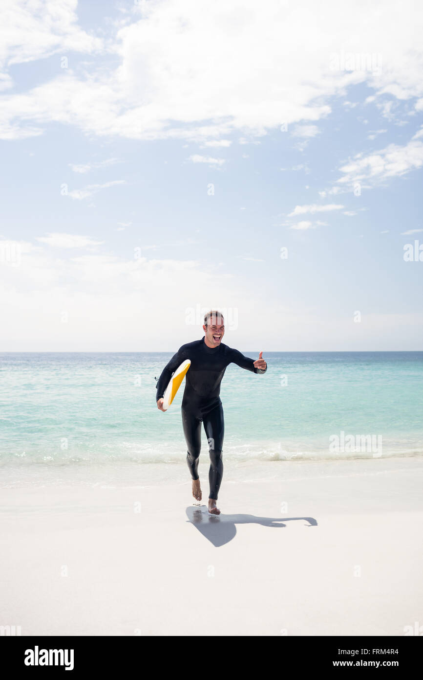 Surfer running on the beach with a surfboard Stock Photo - Alamy