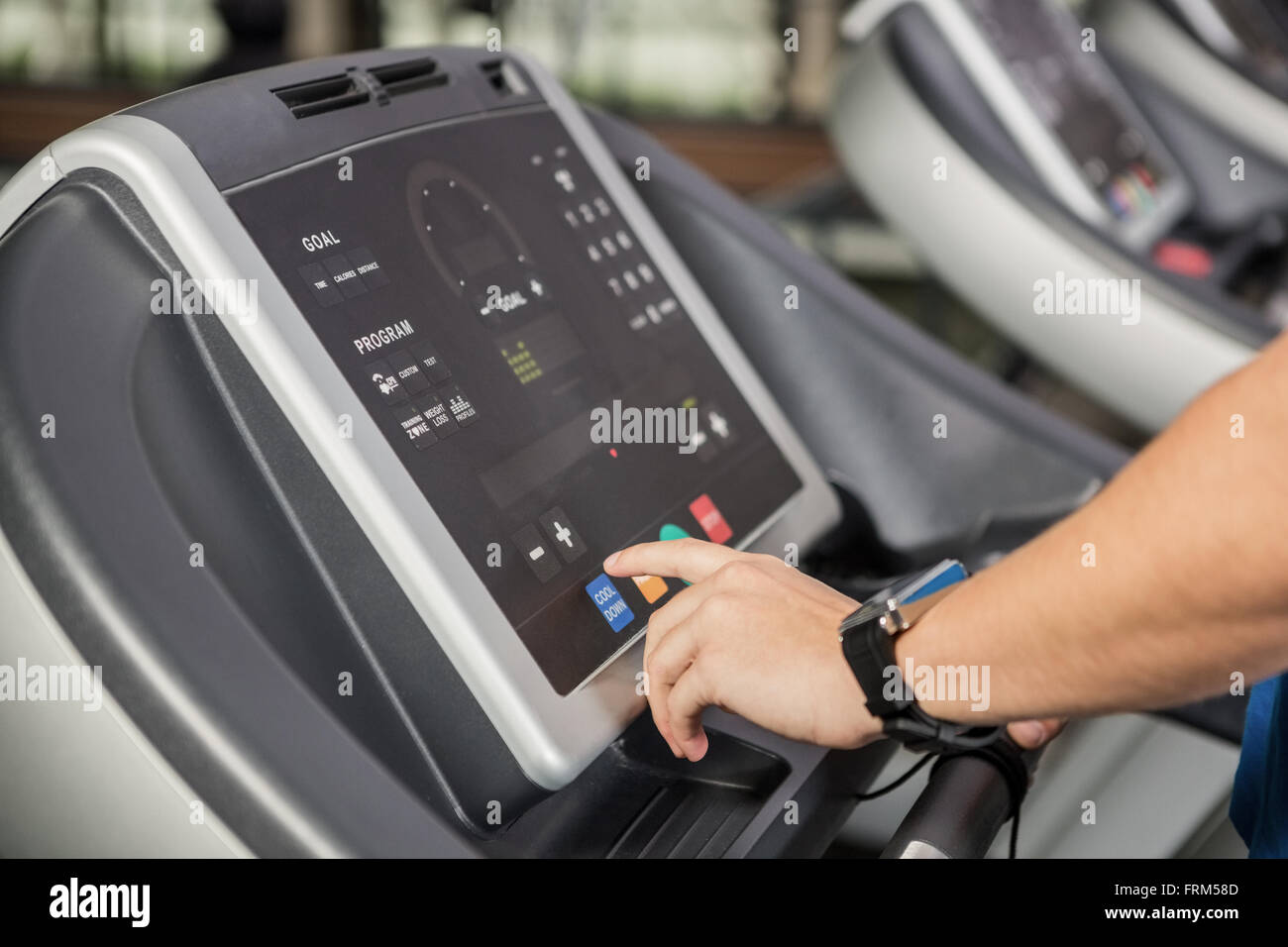Hand pressing a button on the console display of a treadmill Stock ...