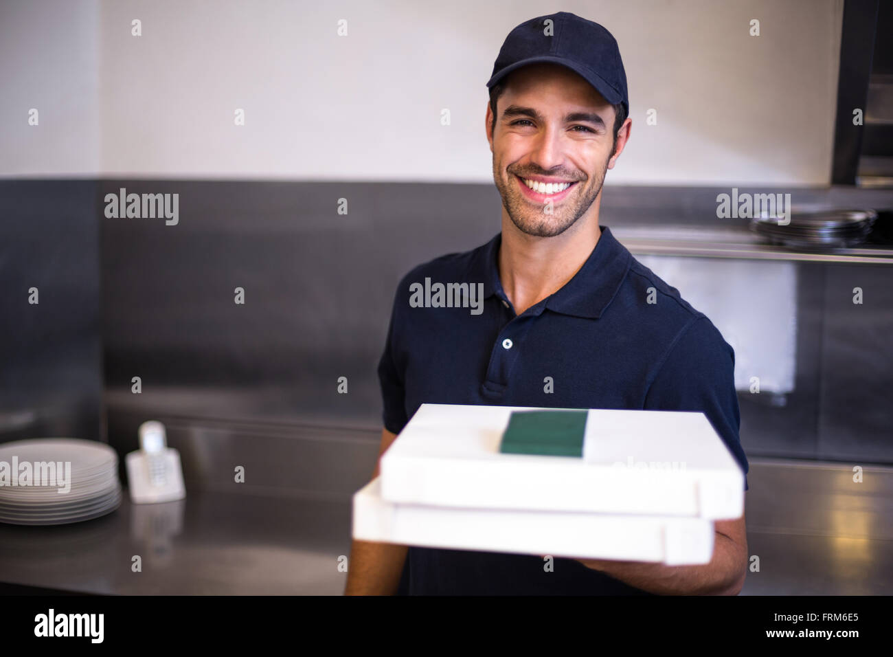 Pizza delivery man showing box Stock Photo - Alamy