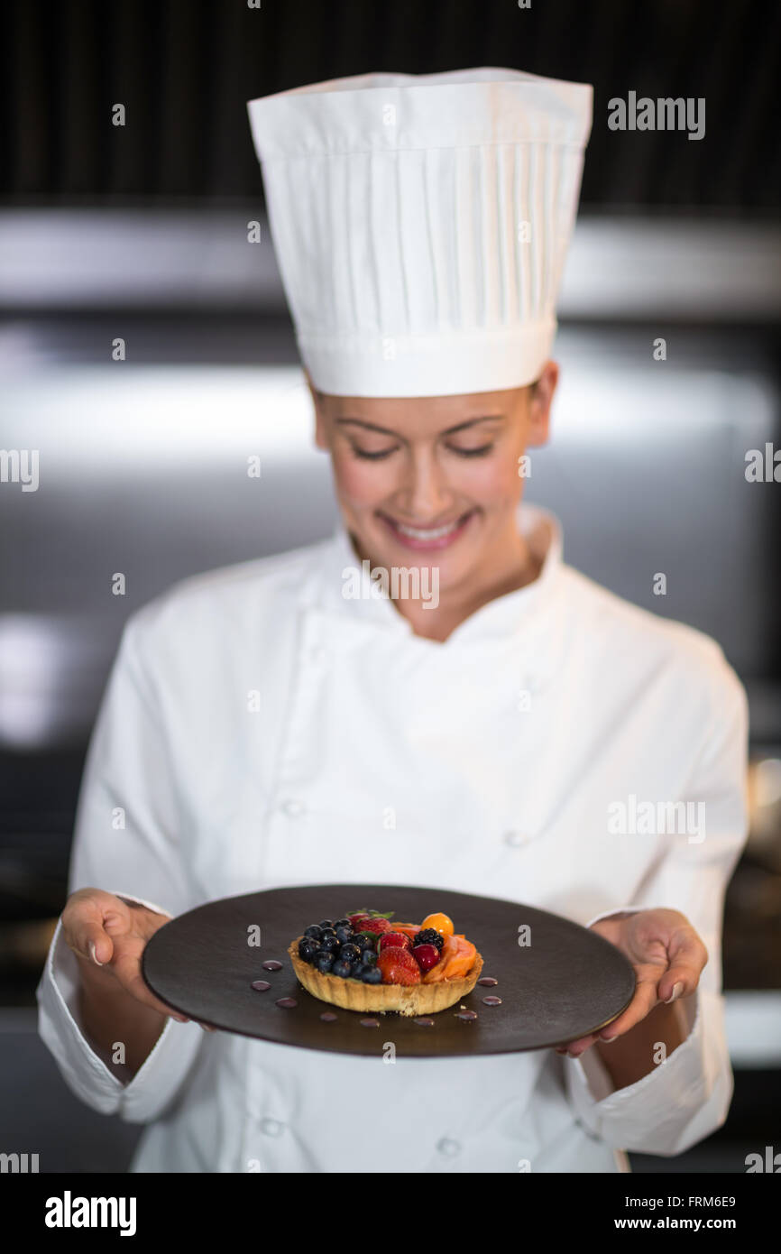 Happy female chef holding plate of dessert Stock Photo - Alamy
