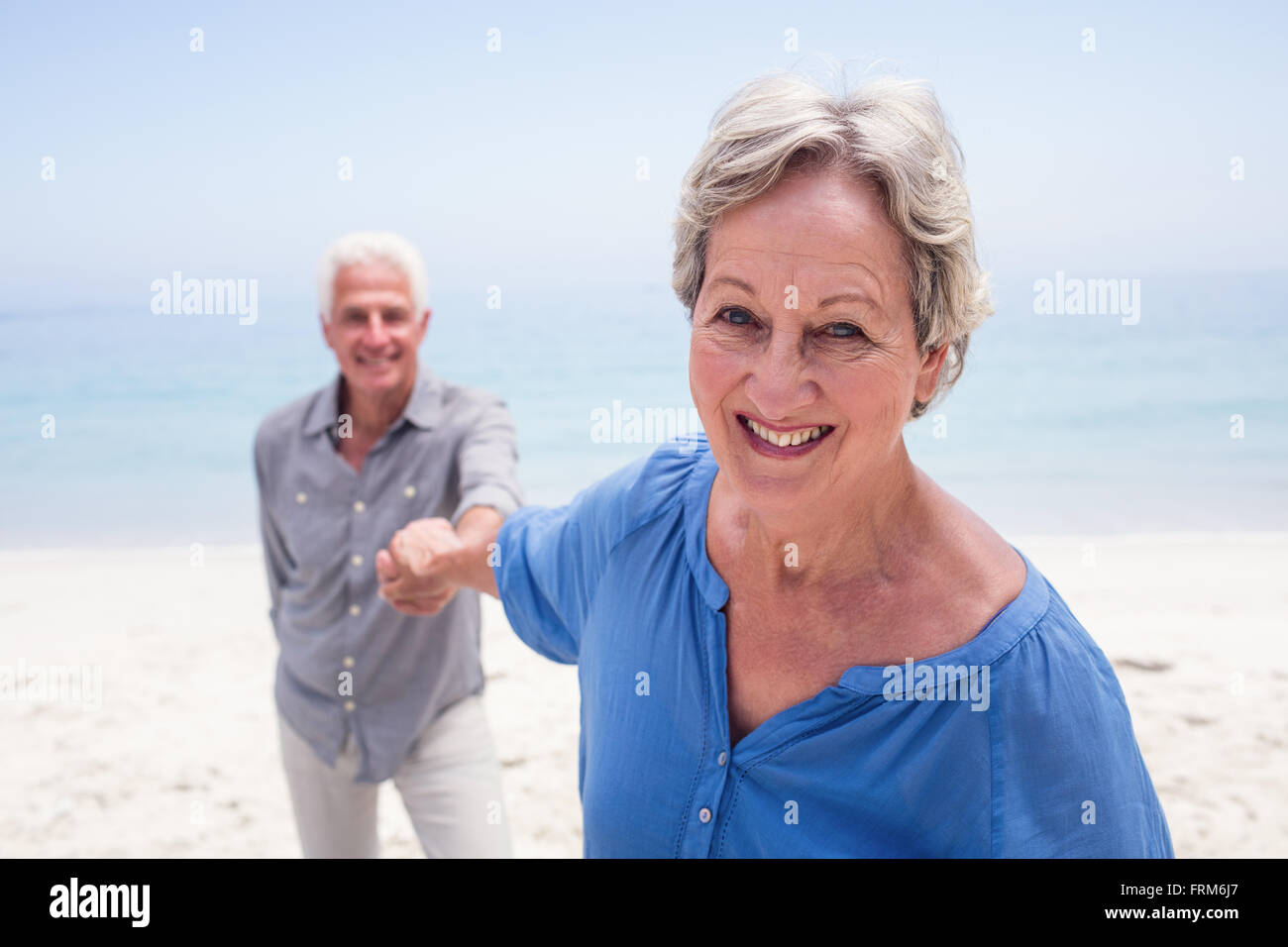 Happy senior couple holding hand on the beach Stock Photo - Alamy