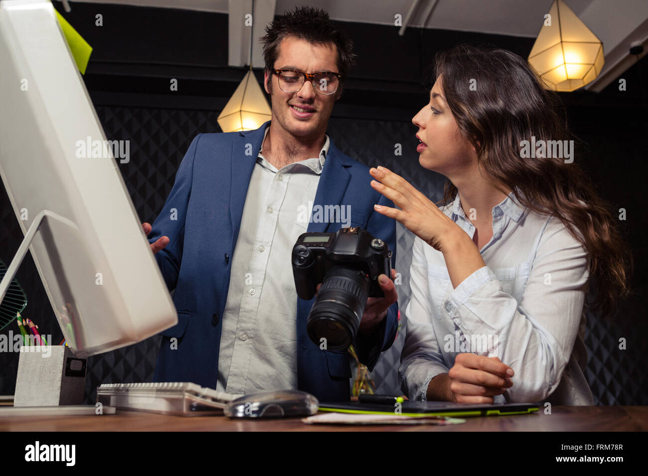 Creative business people looking at pictures on camera Stock Photo - Alamy