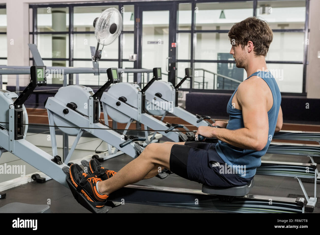 Man working out on rowing machine Stock Photo - Alamy