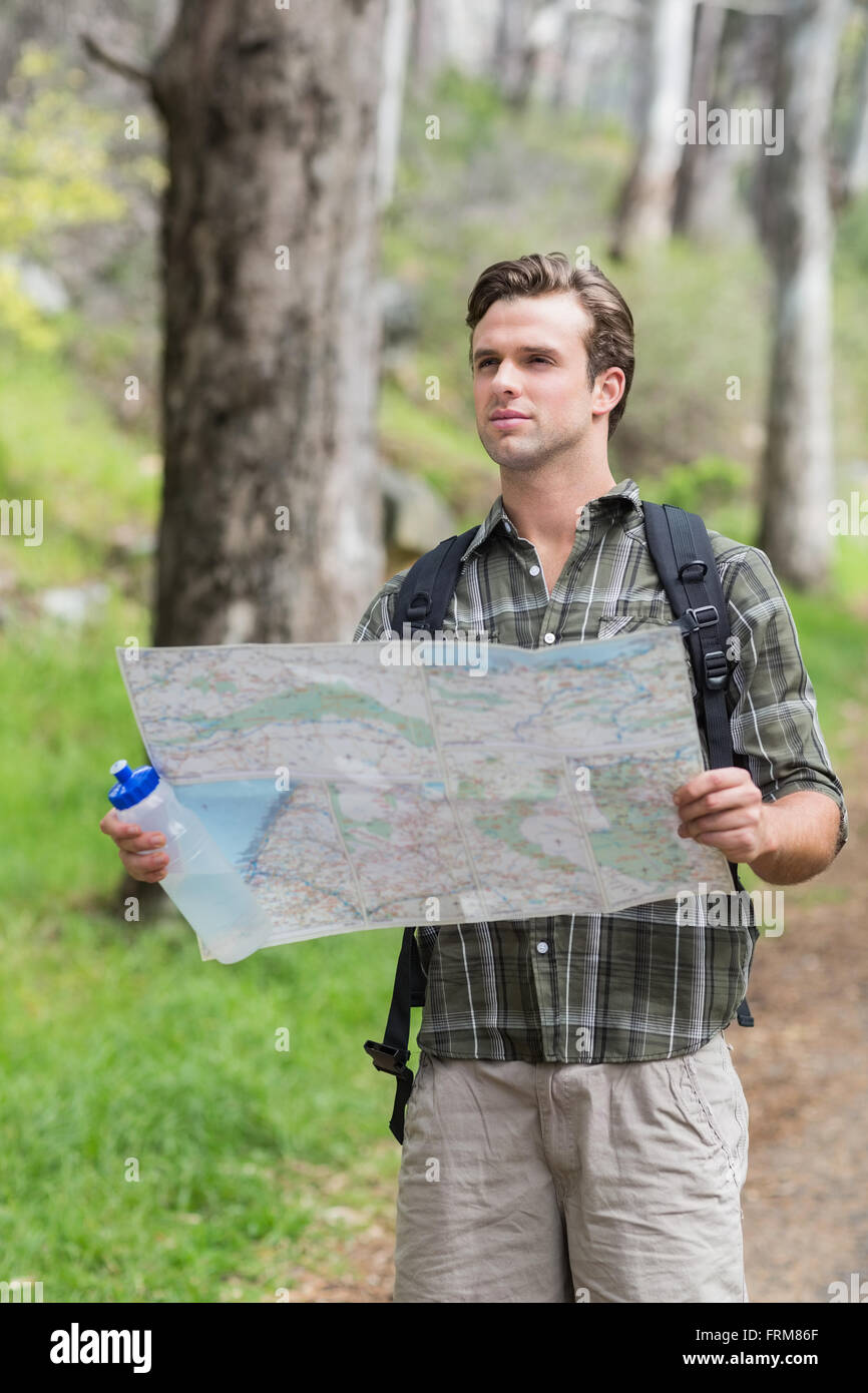 Young man with map against tree Stock Photo - Alamy