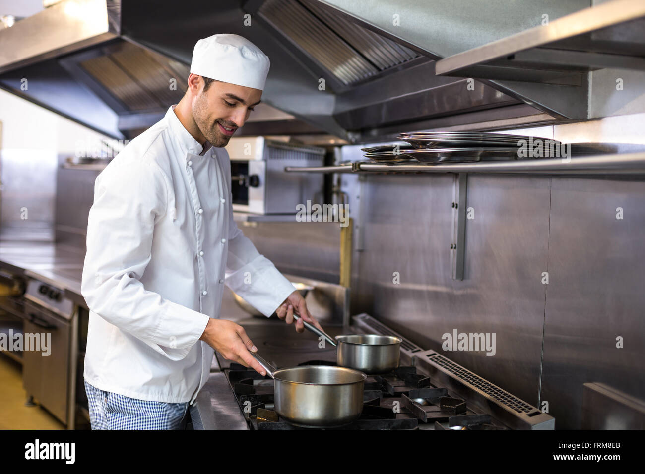 Chef looking at pans Stock Photo - Alamy