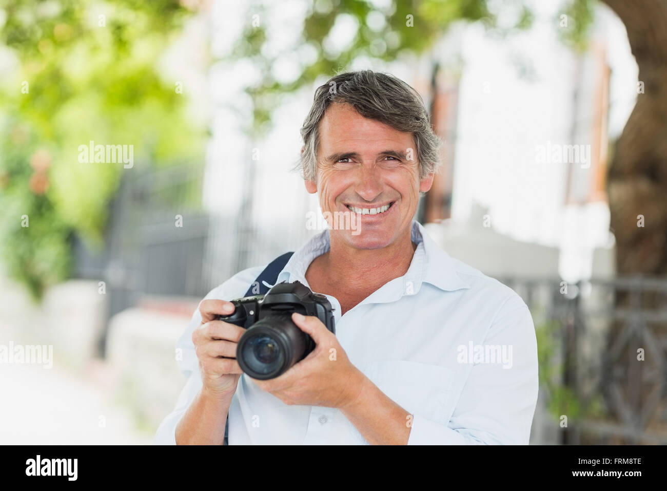 Portrait of happy man with camera Stock Photo - Alamy