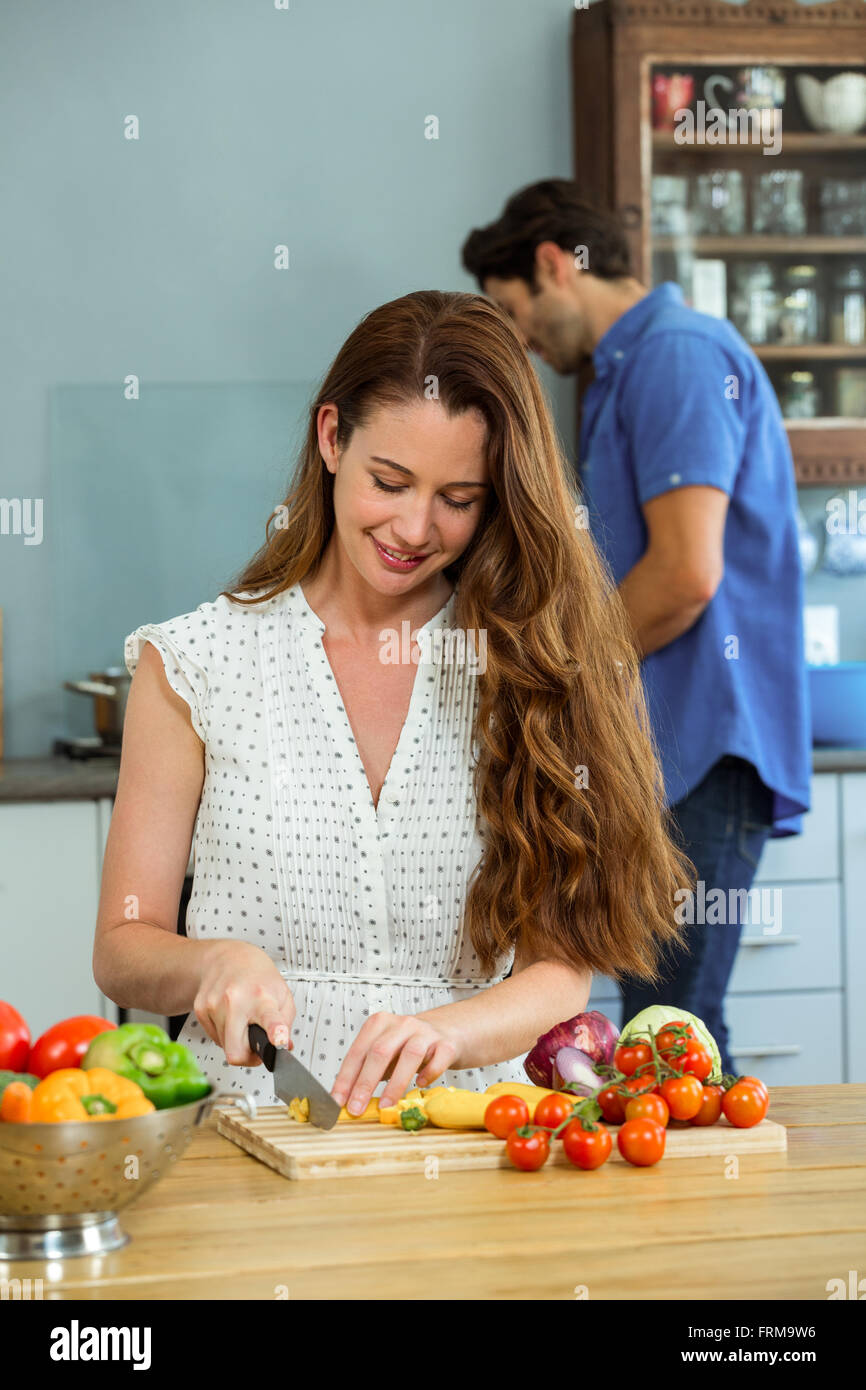 Young woman chopping vegetables in kitchen Stock Photo - Alamy