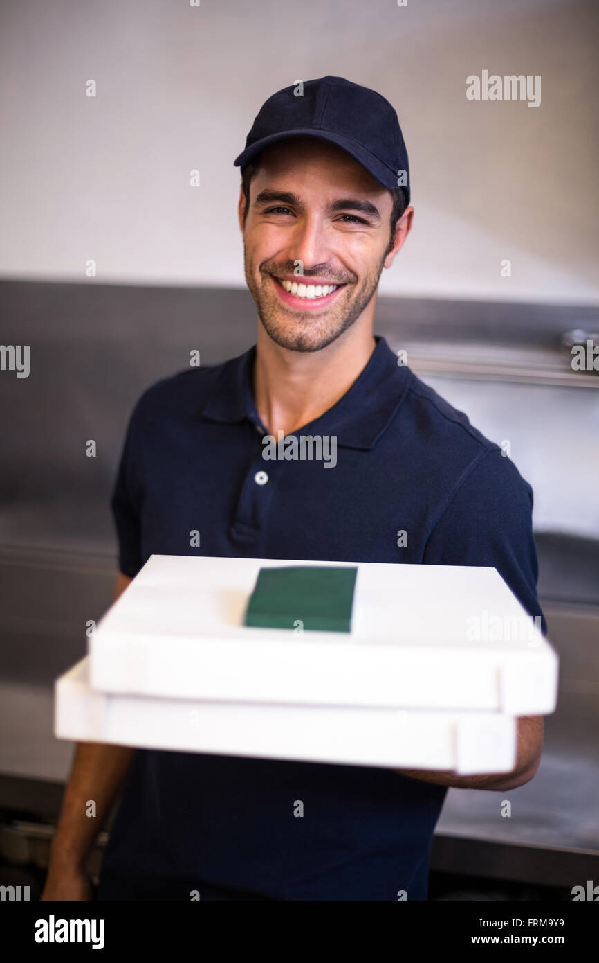 Pizza delivery man showing box Stock Photo - Alamy