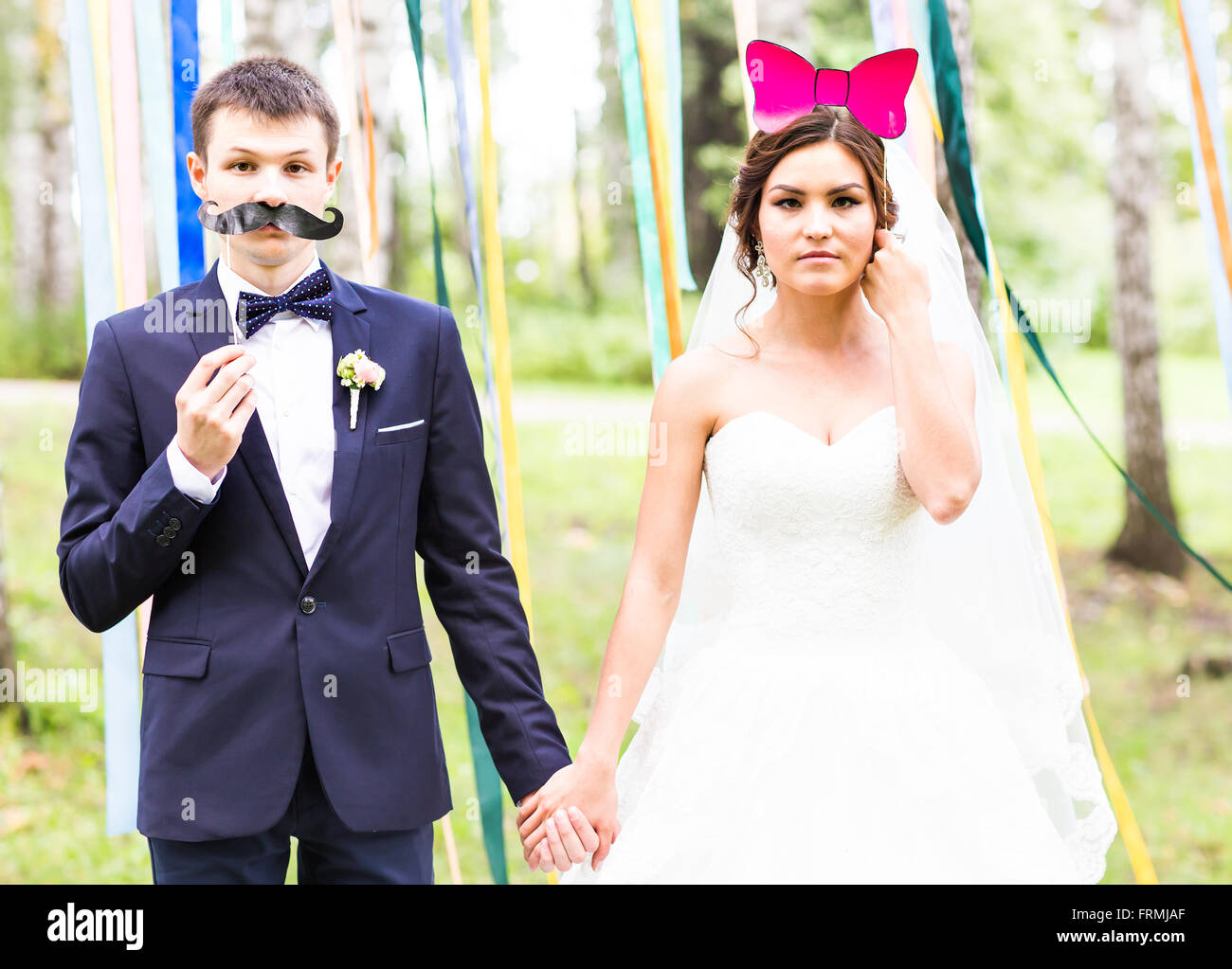 April Fools' Day. Wedding couple posing with mask Stock Photo - Alamy