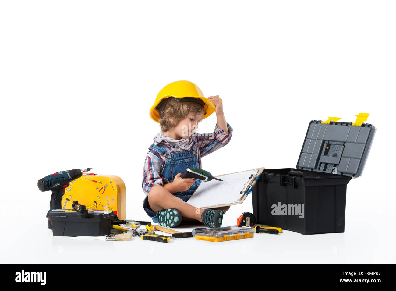 Little boy dressed as utility worker with protective helmet trying to ...