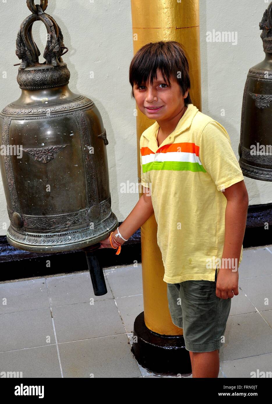 Chiang Mai. Thailand:: A little boy ringing one of the large bronze ...