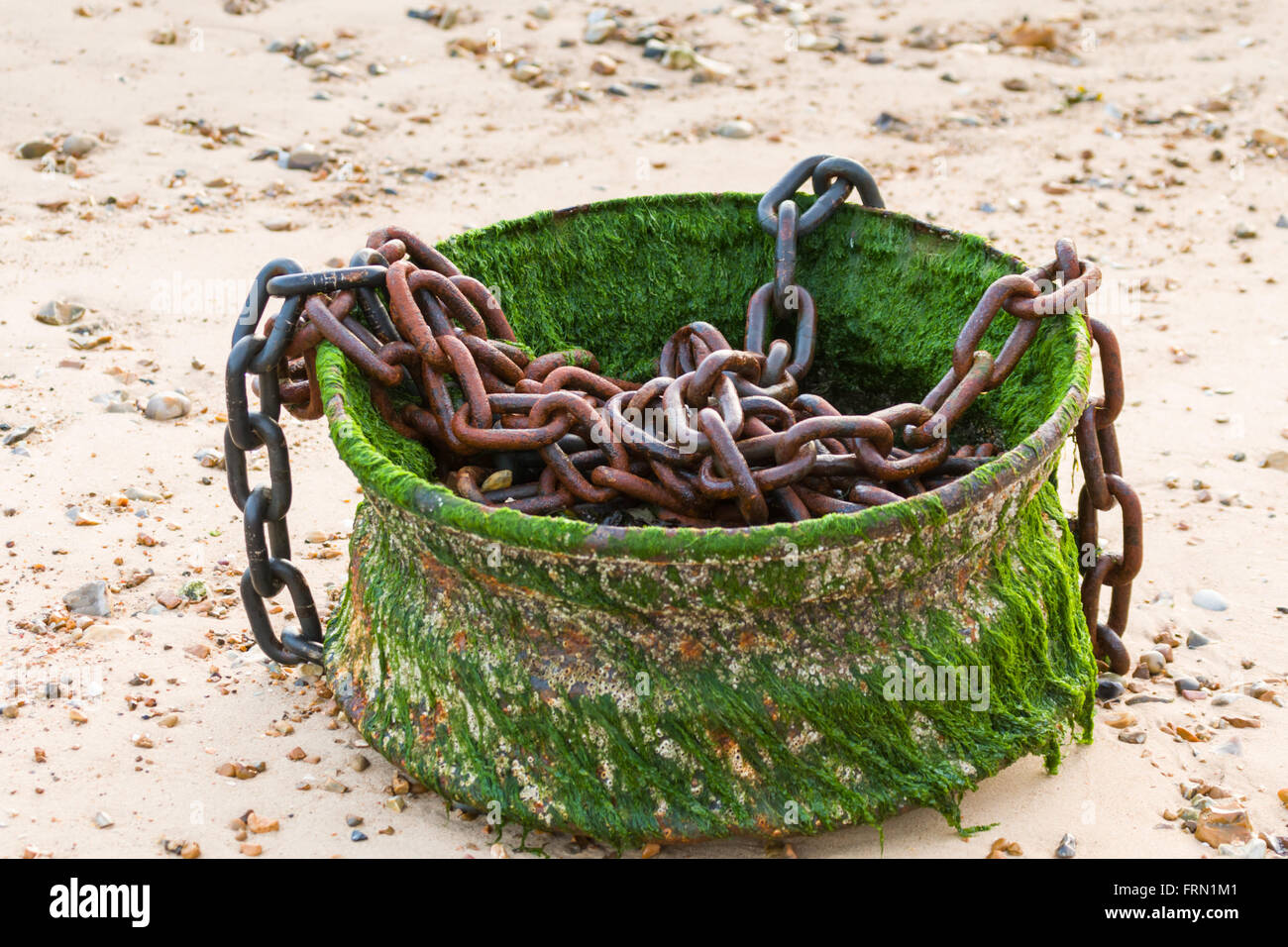 Old car wheel with heavy duty chain hanging out on the beach at Wells ...