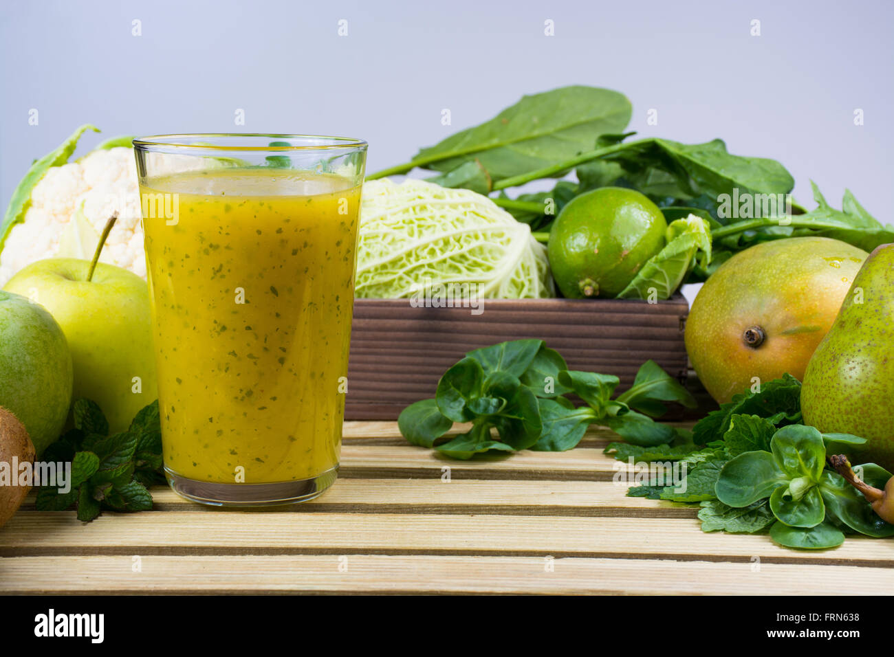 Green fruits and vegetables, fresh pressed smoothie in tall glass on ...