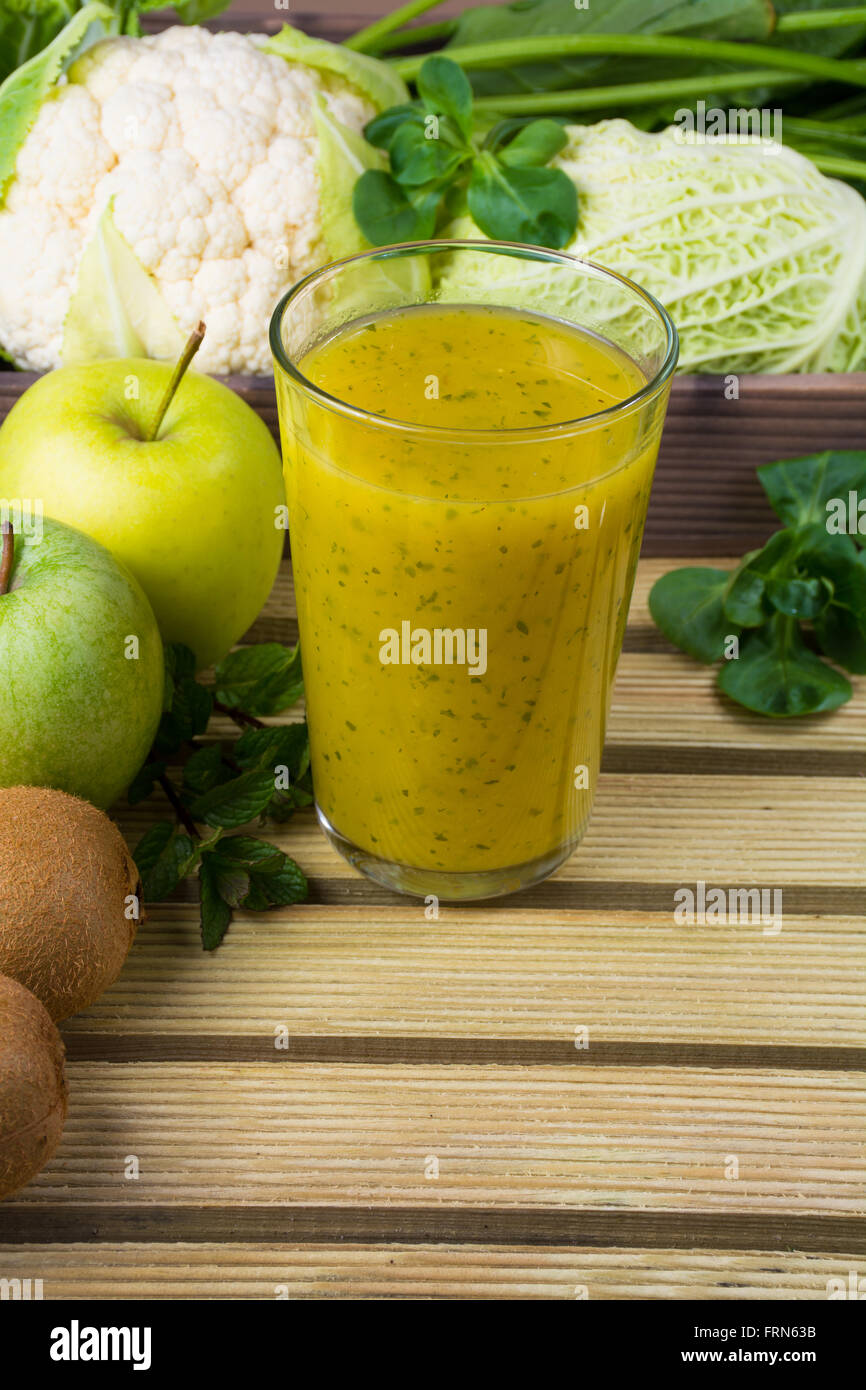 Green fruits and vegetables, fresh pressed smoothie in tall glass on ...