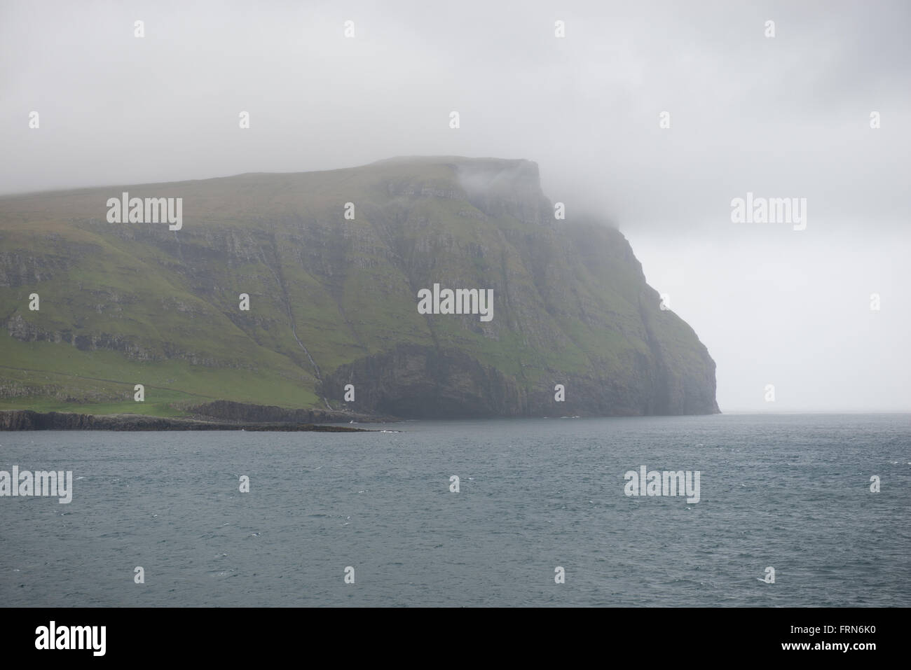 Typical landscape on the Faroe Islands, with green grass, cliff and ...