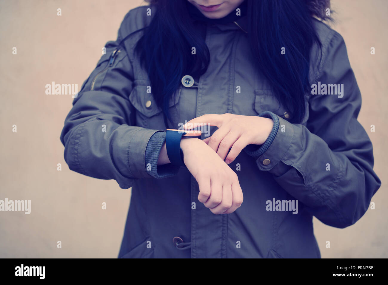 Young girl using her trendy smart wrist watch. This new technology lets ...