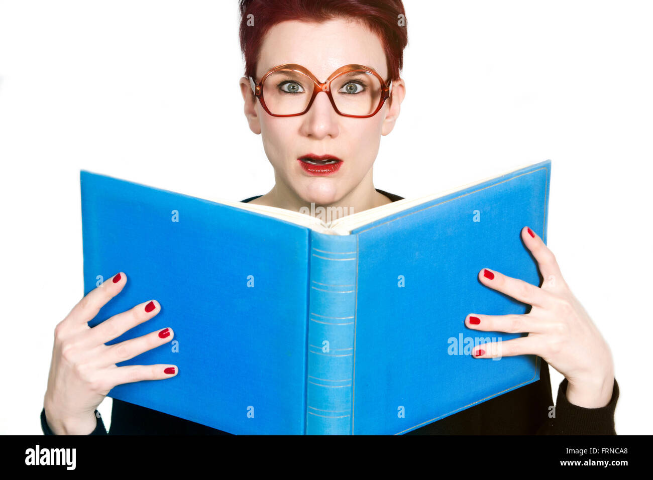 Red Haired Woman With Glasses Reading In A Blue Book And Looking