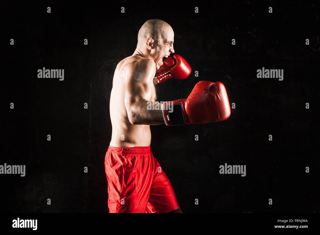 The young man kickboxing on black Stock Photo - Alamy