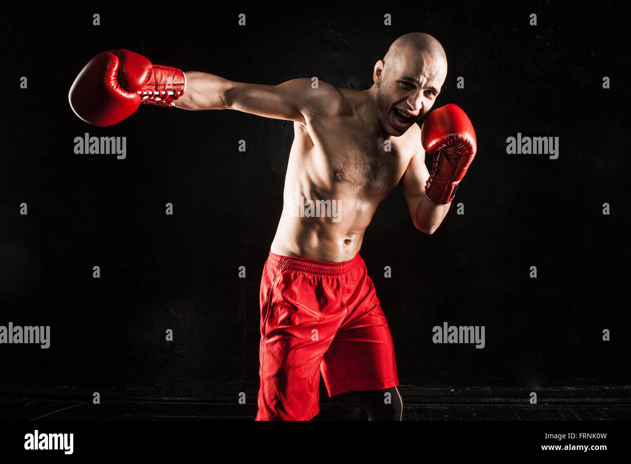The young man kickboxing on black Stock Photo - Alamy