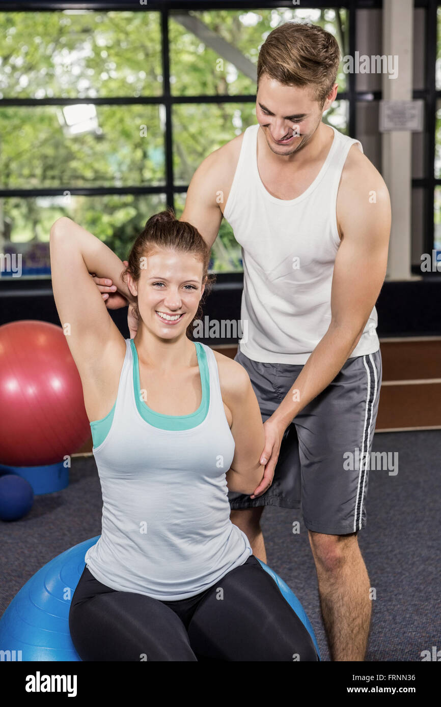 Trainer assisting a woman with stretching exercise Stock Photo - Alamy