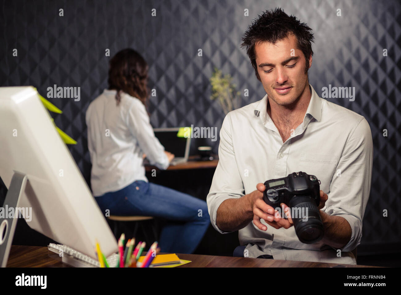 Creative businessman looking at picture on camera Stock Photo - Alamy