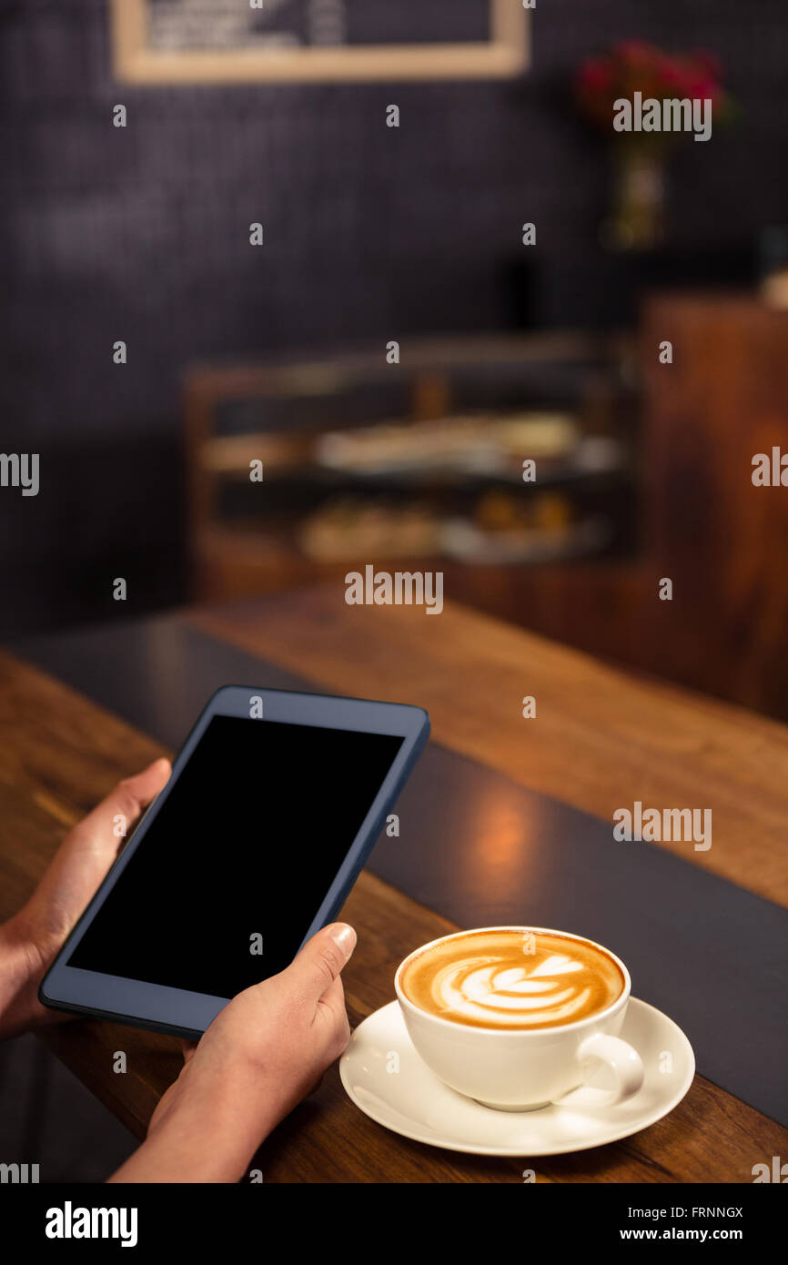 Woman drinking coffee and using tablet Stock Photo - Alamy