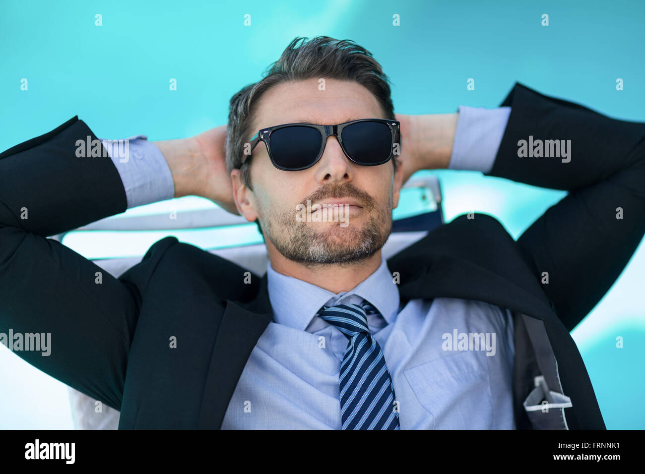 Smart man relaxing on sun lounger Stock Photo - Alamy