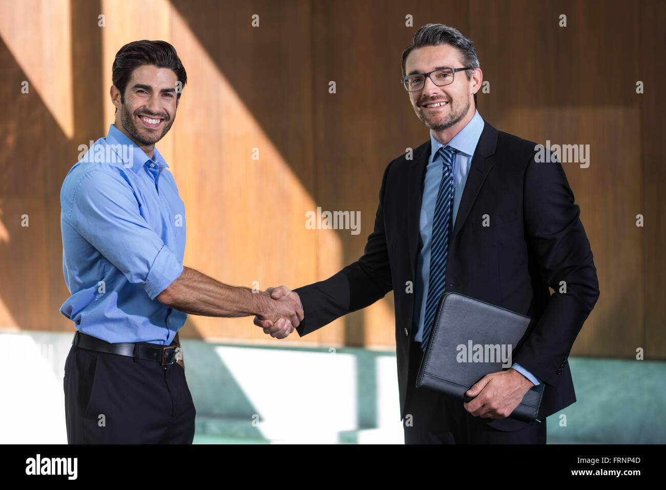 Portrait of businessman shaking man's hand Stock Photo - Alamy