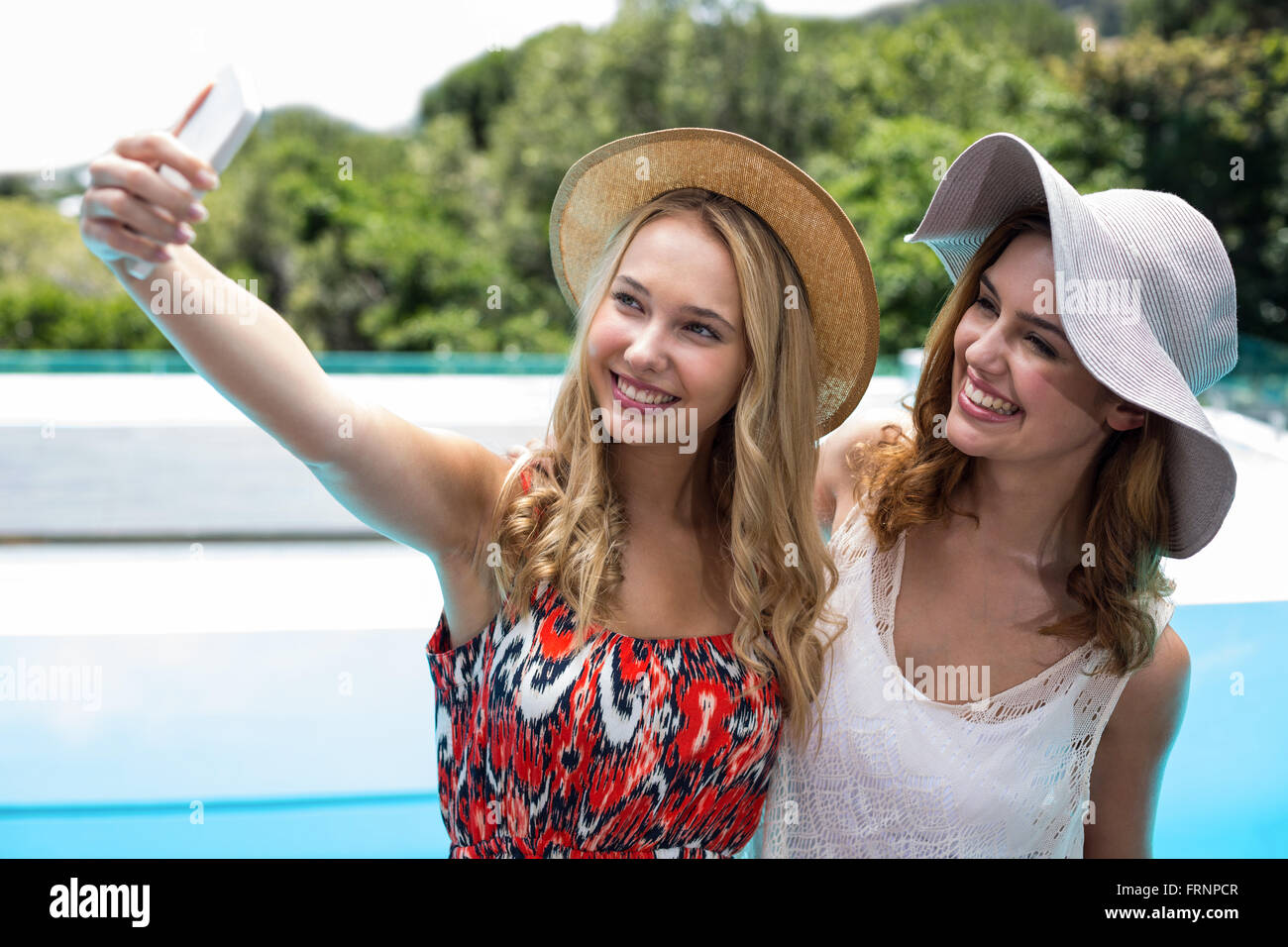 Beautiful women taking a selfie by swimming pool Stock Photo - Alamy
