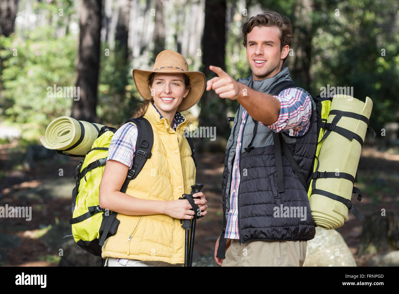 Young man pointing away during hiking with partner Stock Photo - Alamy
