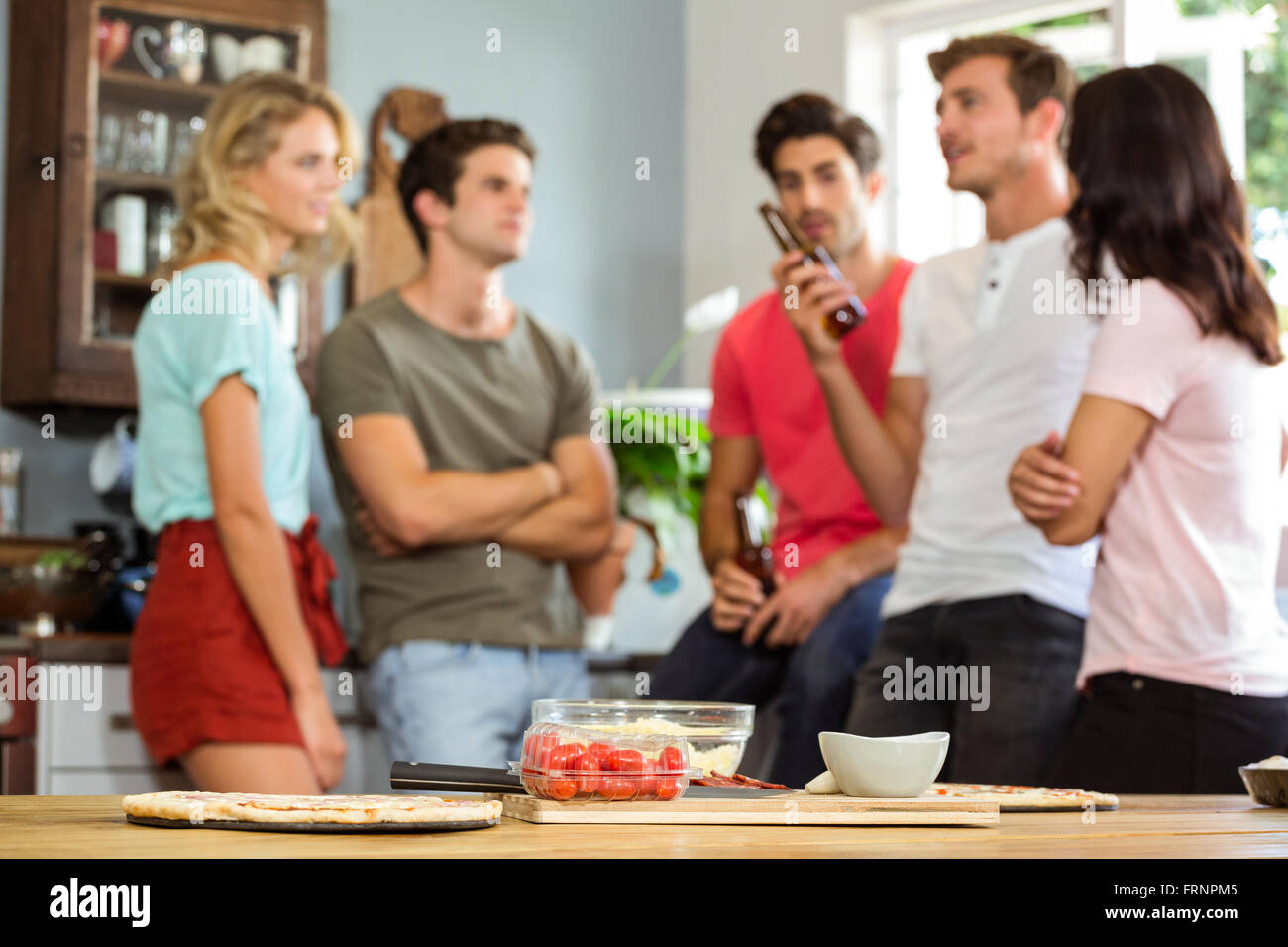 Group of young friends talking in kitchen Stock Photo - Alamy