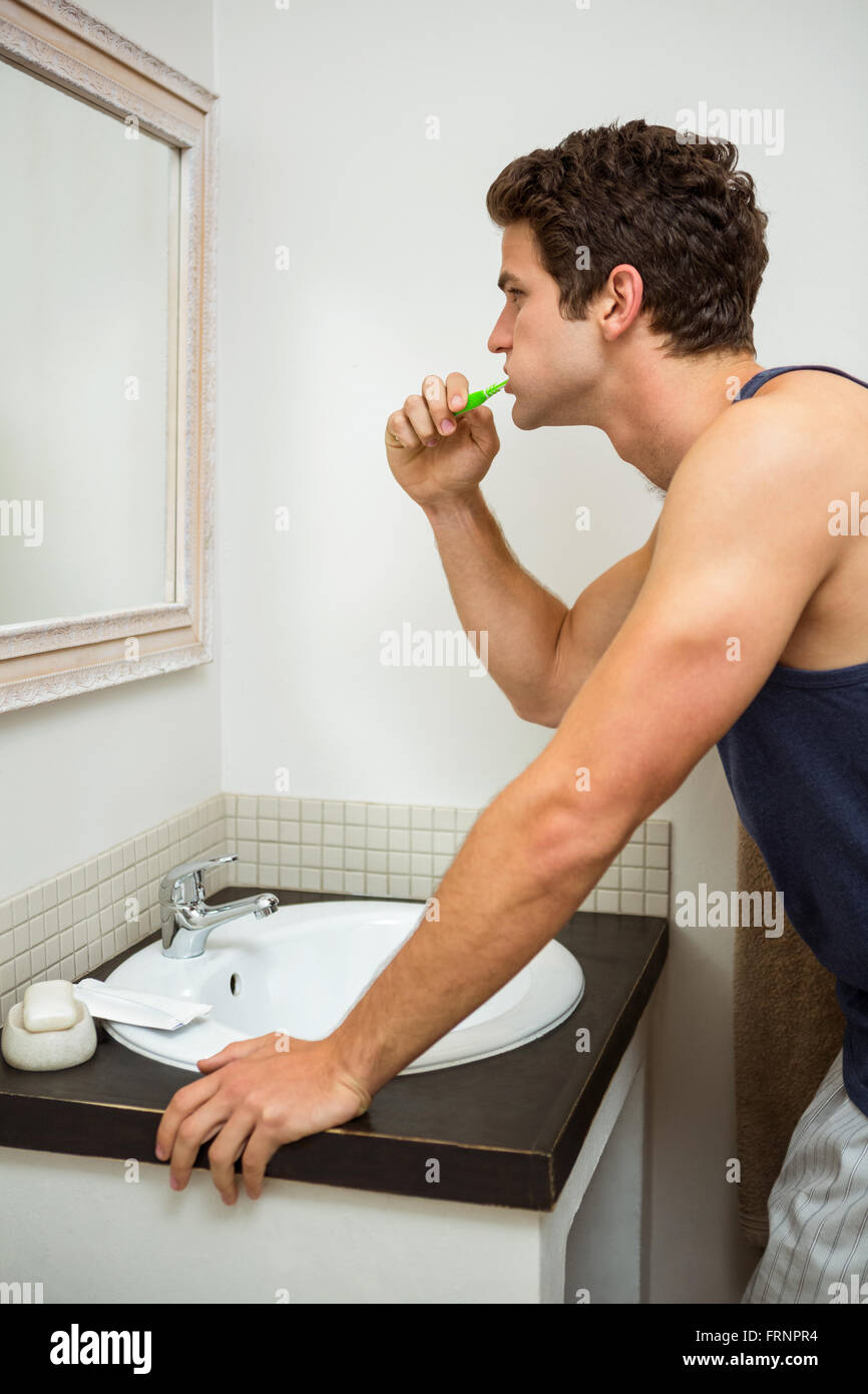 Young man brushing his teeth in bathroom Stock Photo - Alamy