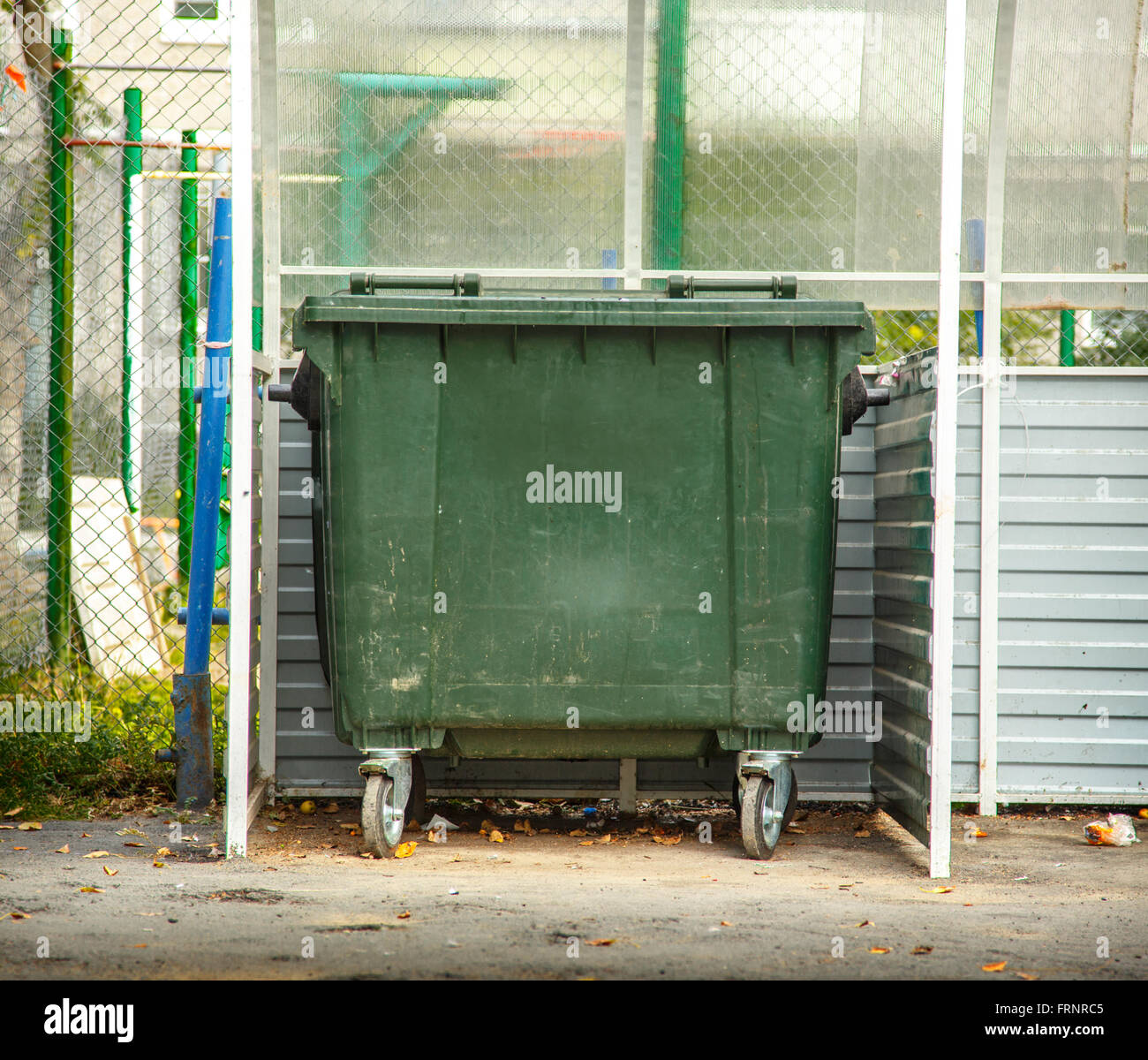 Photo of single green garbage bin outside Stock Photo - Alamy