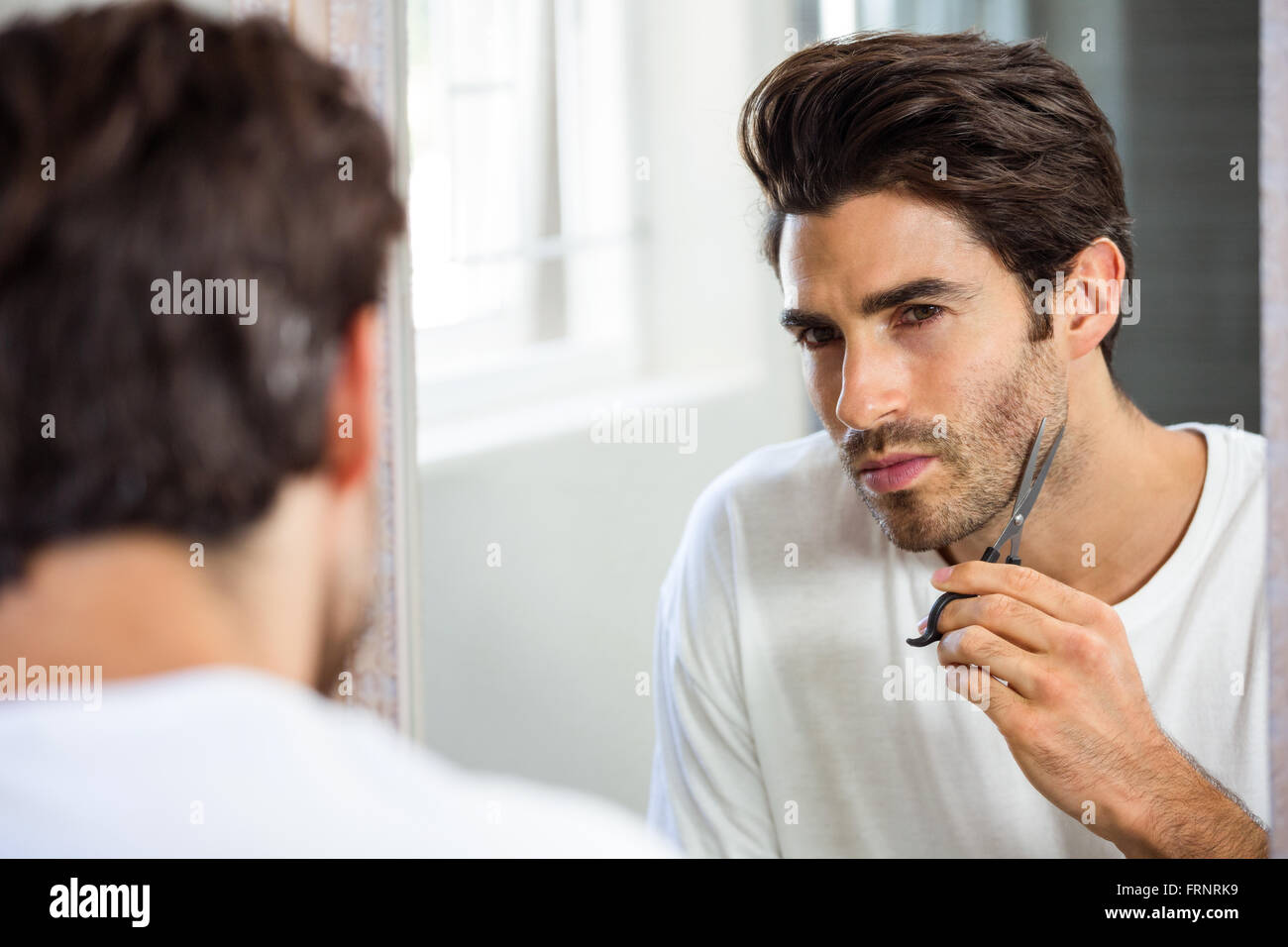 Young man cutting beard Stock Photo - Alamy