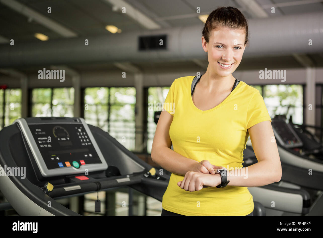 Portrait of happy woman using smart watch on treadmill Stock Photo - Alamy