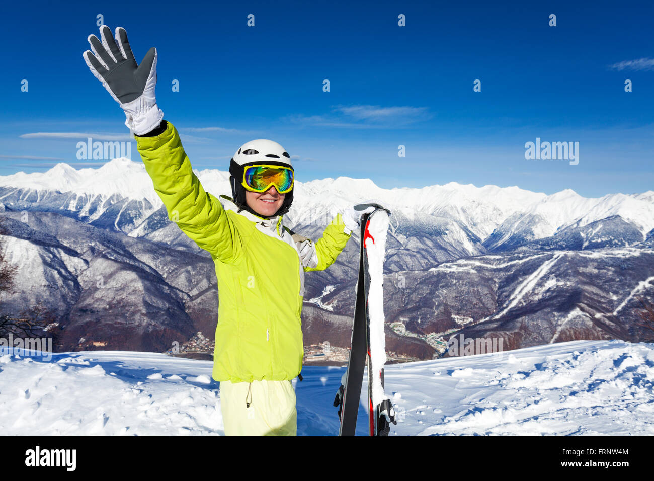 Skier woman wave hand and hold ski Stock Photo - Alamy
