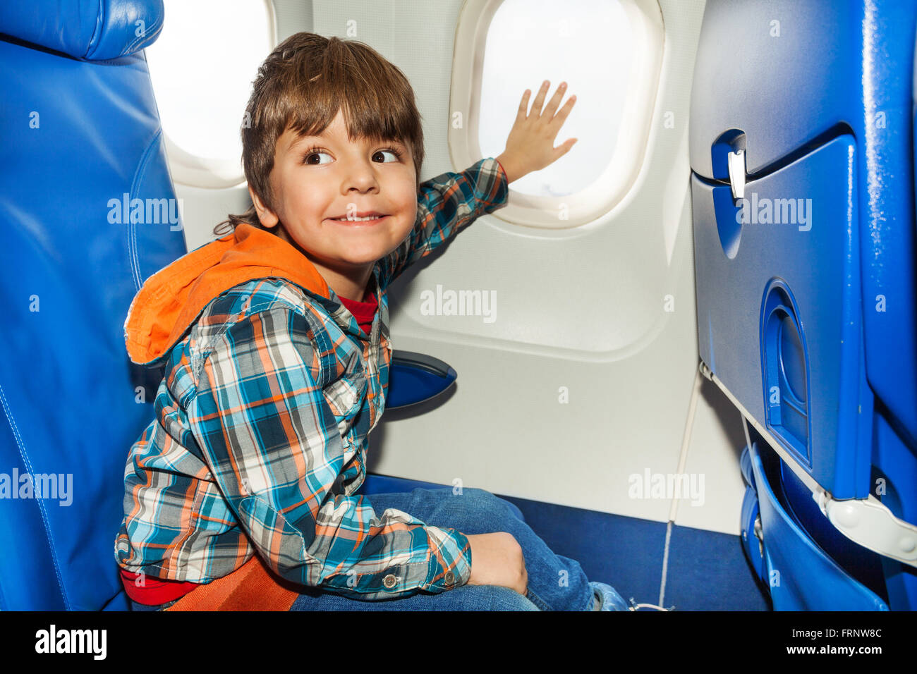 Child on airplane touch window with hand Stock Photo - Alamy