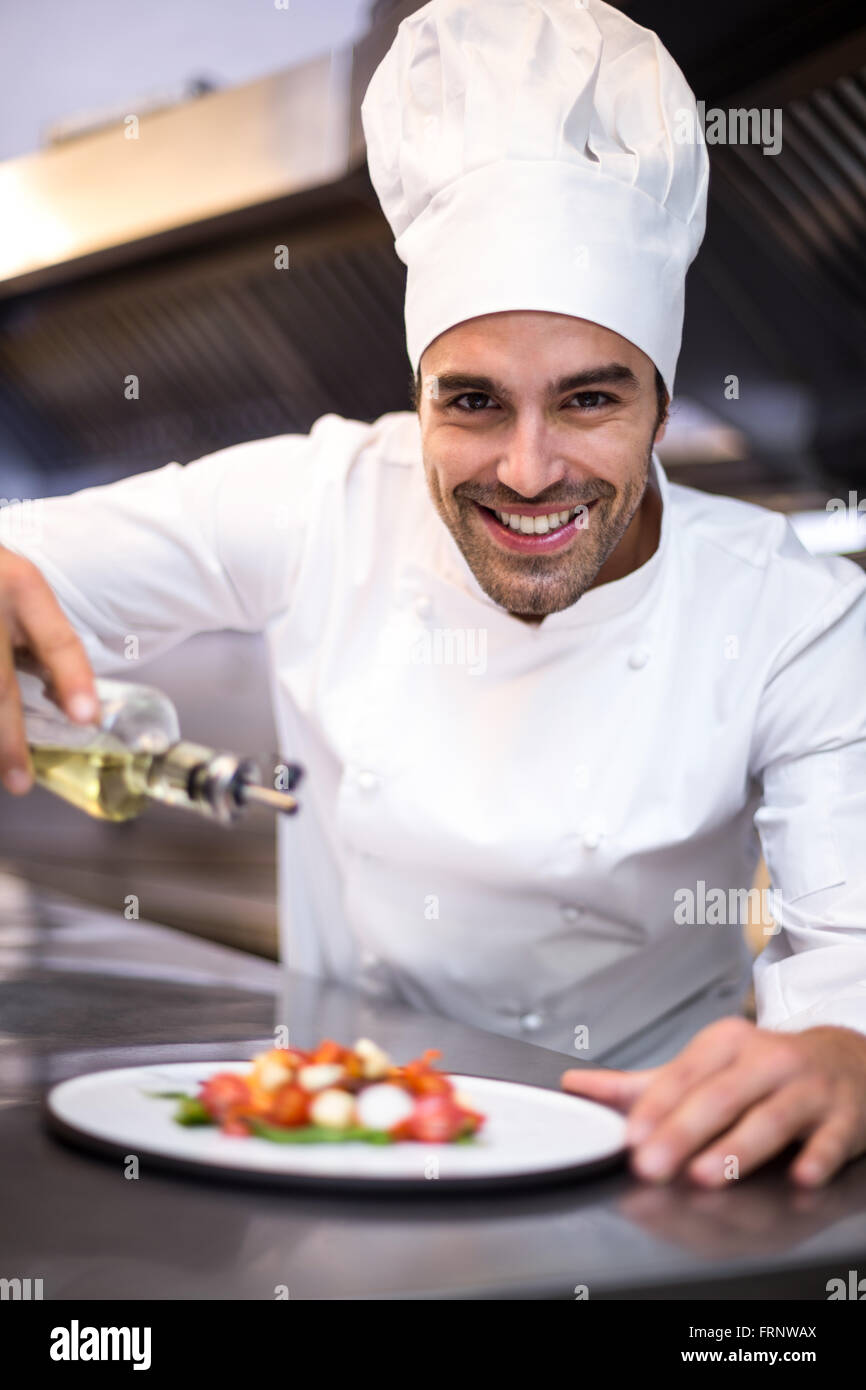 Handsome chef pouring olive oil on meal Stock Photo - Alamy