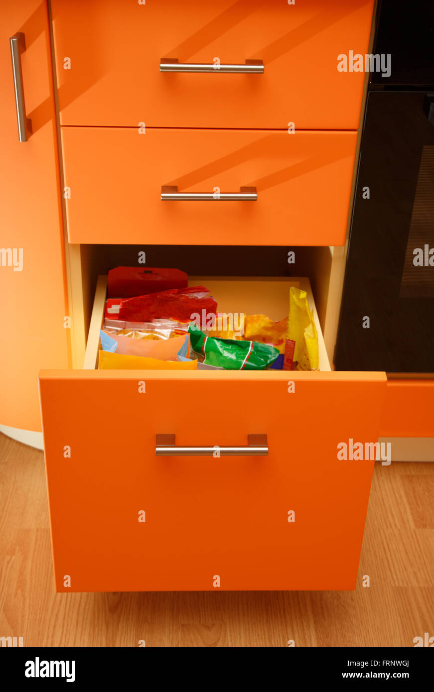 Orange wooden kitchen drawers with one open Stock Photo - Alamy