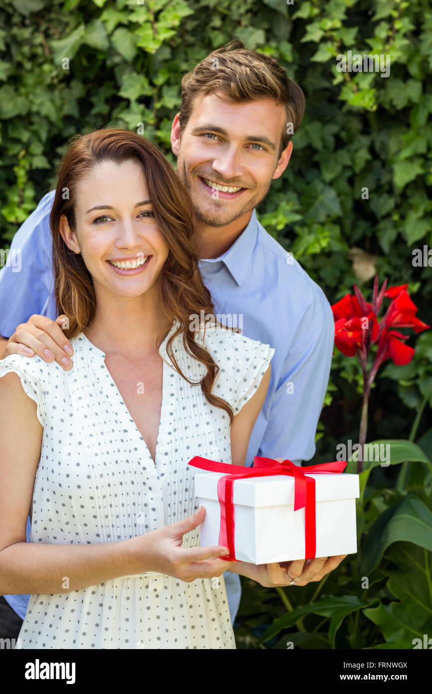 Happy man giving gift to woman at front yard Stock Photo - Alamy