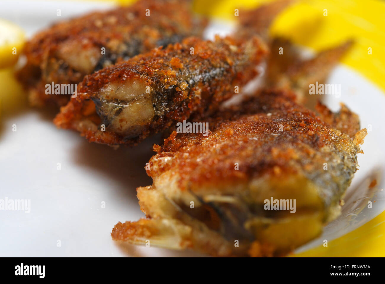 fried fish with lemon on a plate Stock Photo - Alamy