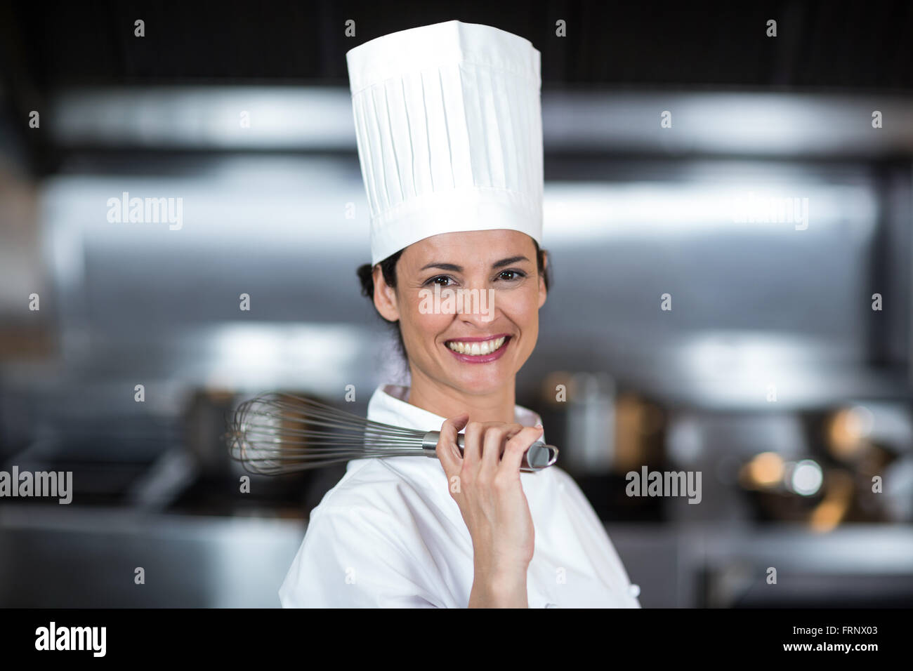 Portrait of smiling female chef holding wire whisk Stock Photo - Alamy