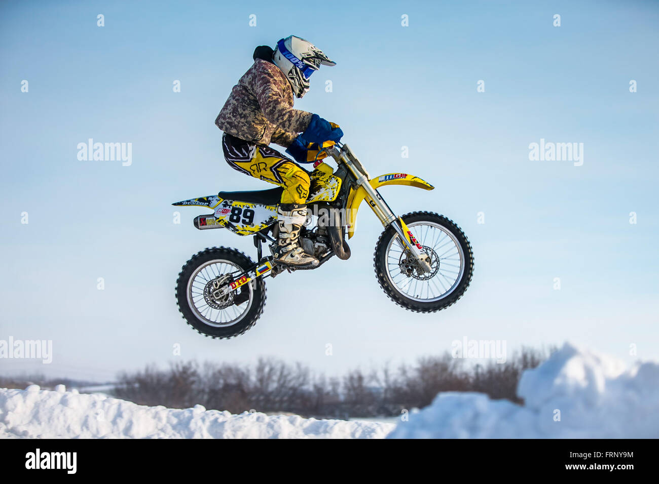 closeup rider on a motorcycle jump on mountain. background blue sky ...